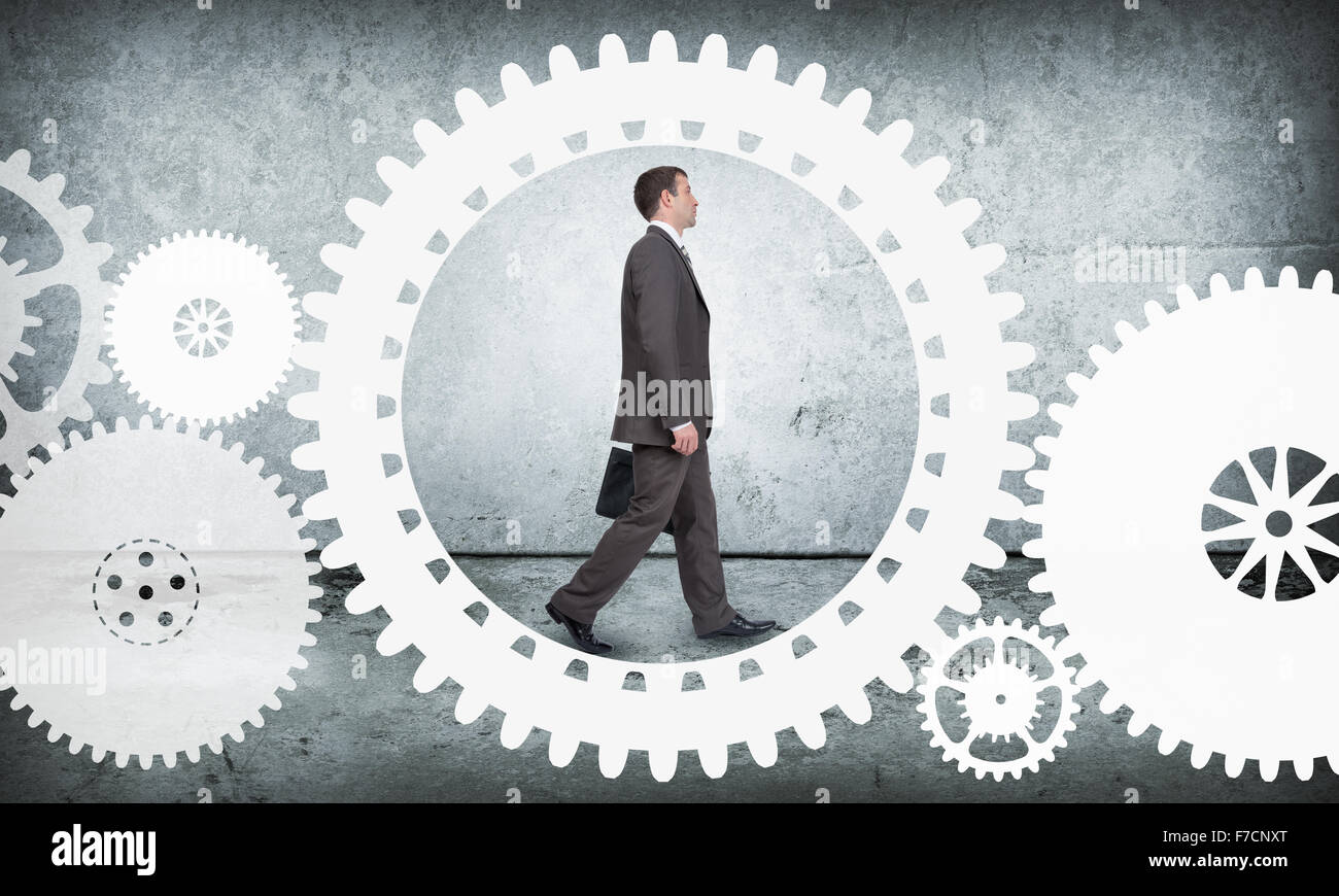 Businessman walking in cog wheel, side view Stock Photo - Alamy