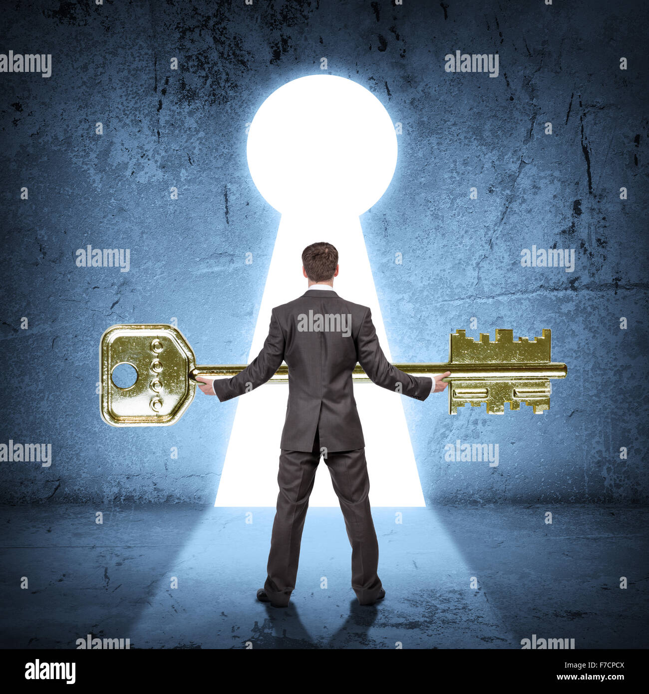 Man holding huge gold key, rear view Stock Photo - Alamy