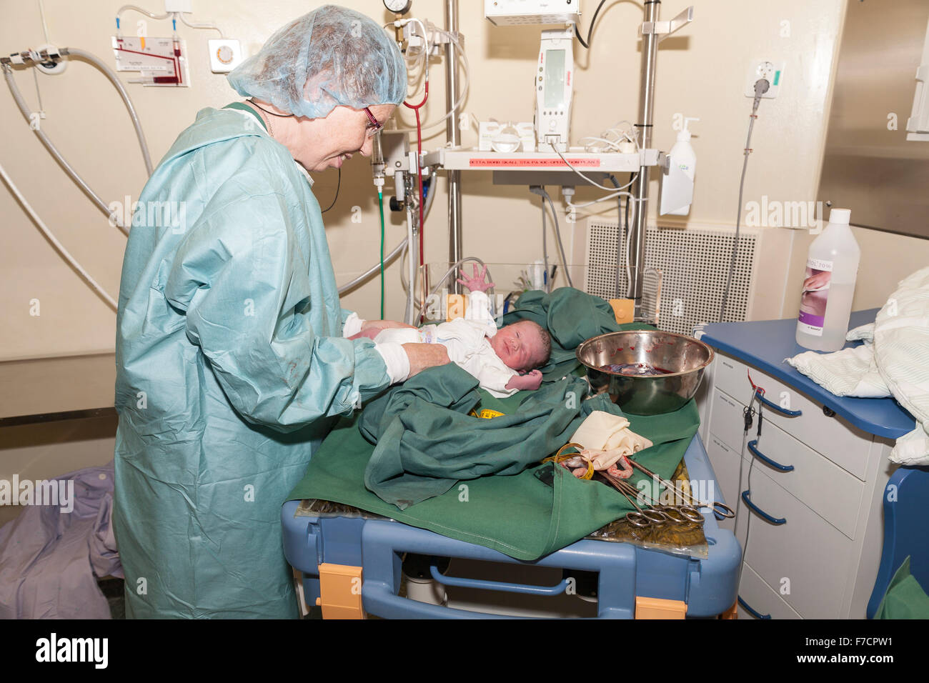 Newborn baby boy having his first medical examination after caesarean ...