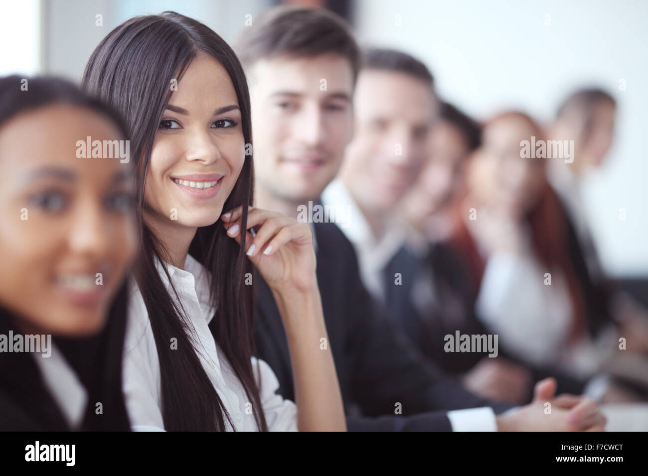 Business people sitting in a row and working, focus on pretty woman ...
