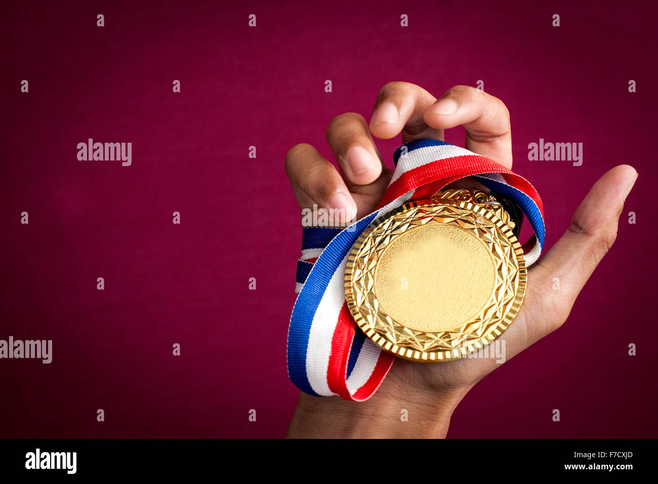 hand holding up a gold medal as a winner as a winner in a competition ...