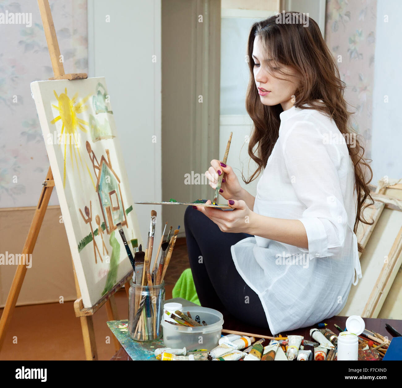 Yuong adult artist paints the house on canvas in studio Stock Photo - Alamy