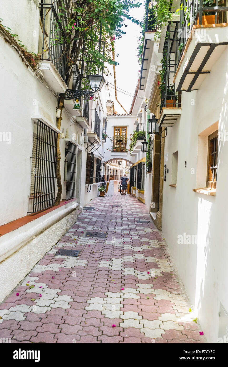 Tourism, narrow streets and typical of Marbella, white walls with ...