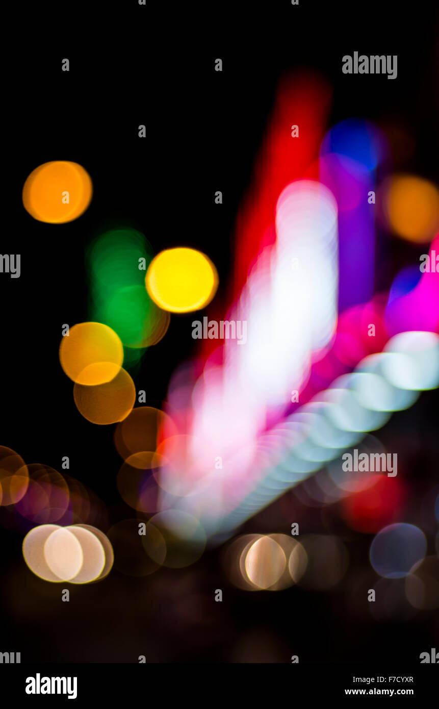 Abstract background of blurred coloured lights on a black background ...