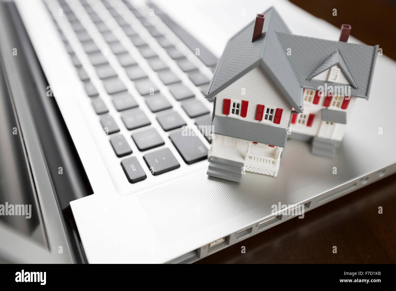 Miniature House And Laptop Computer Resting on Desktop Stock Photo - Alamy