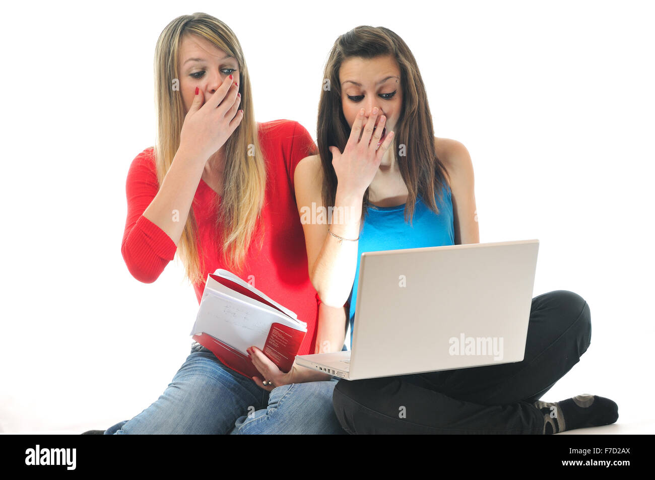 scared and shocked two young woman isolated looking in laptop Stock ...