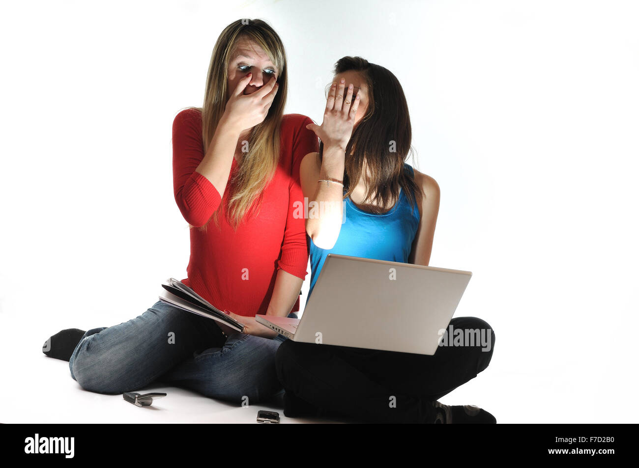 scared and shocked two young woman isolated looking in laptop Stock ...