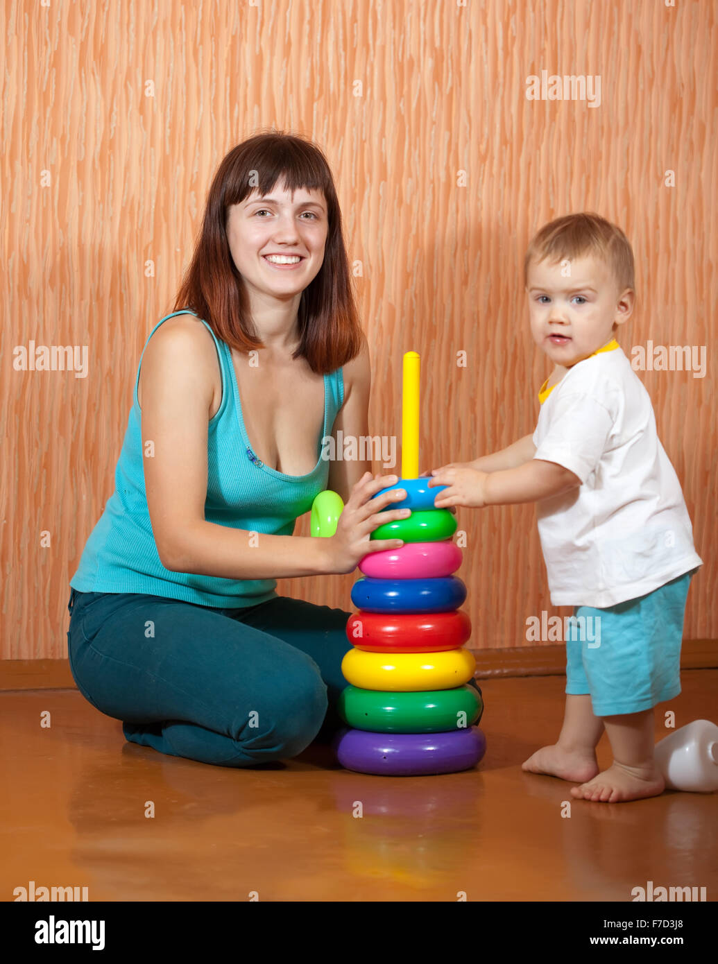 Happy mother and baby plays with pyramidion in home. Focus on woman ...
