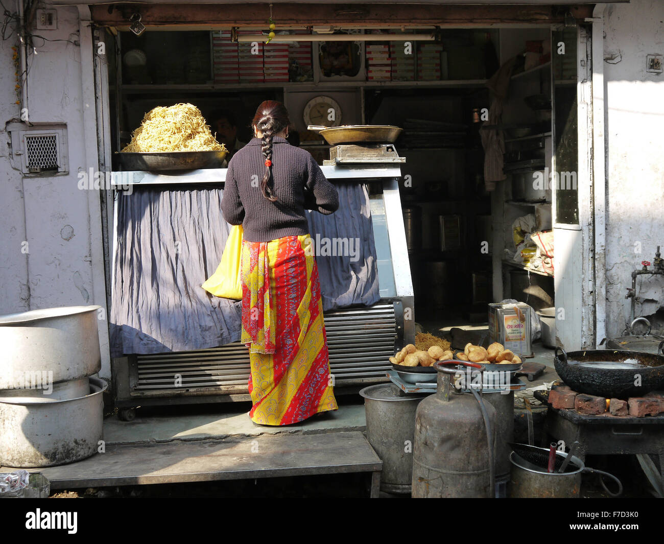 Indian woman waits patiently at food kiosk in Jaipur . She stands ...