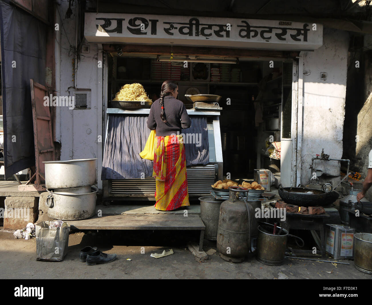 Indian woman waits patiently at food kiosk in Jaipur . She stands ...
