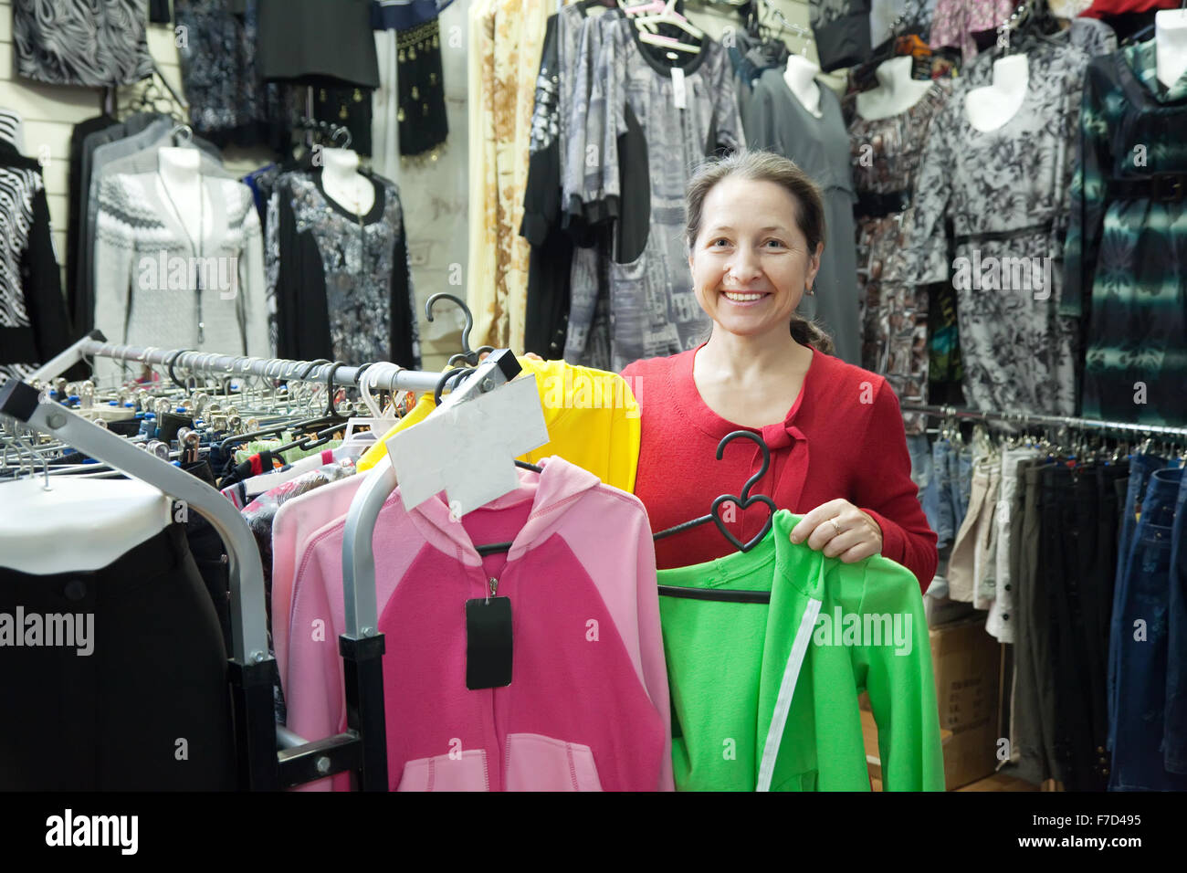 Woman chooses clothes at fashionable shop Stock Photo - Alamy