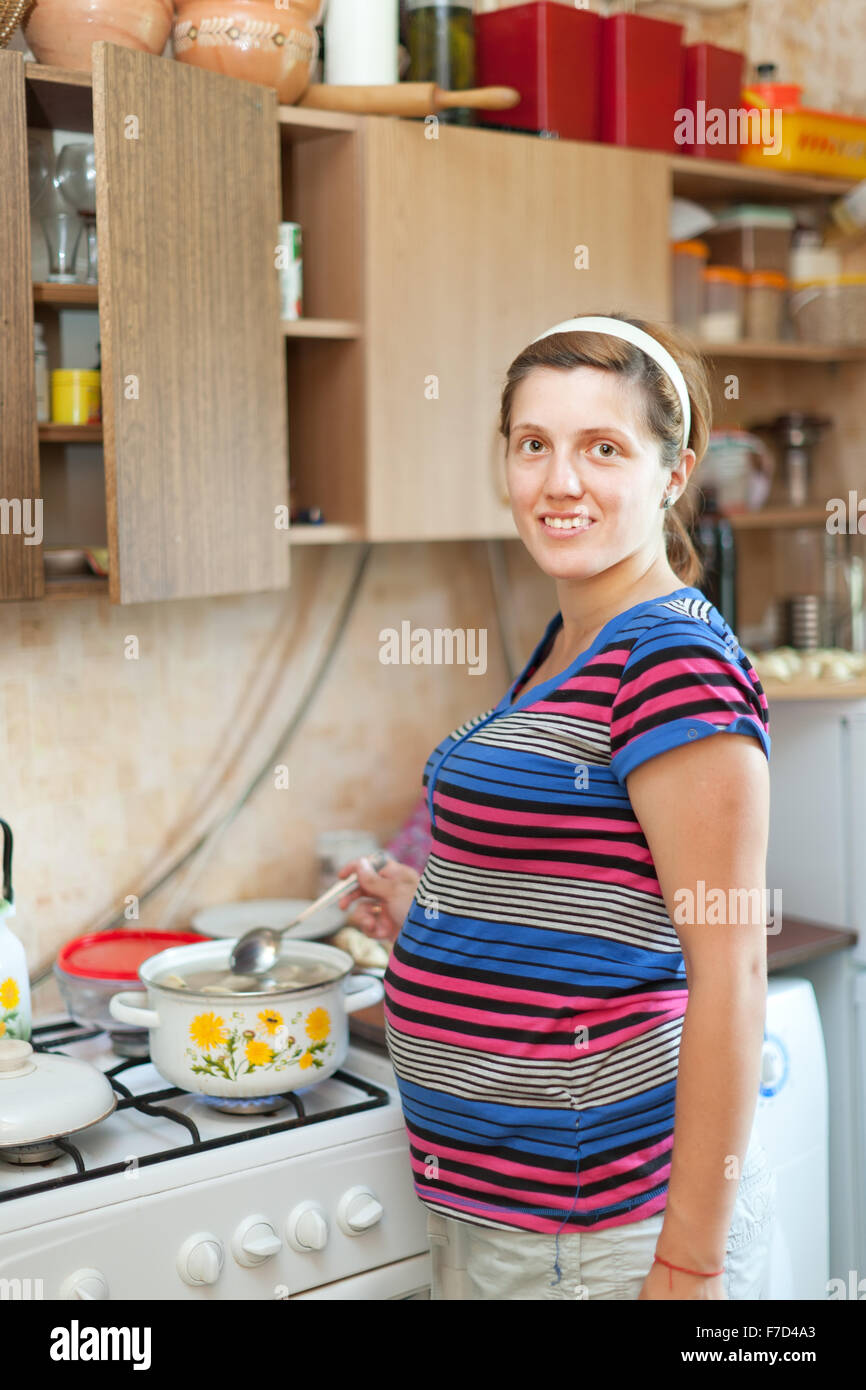 pregnant woman cooking food in her kitchen Stock Photo - Alamy