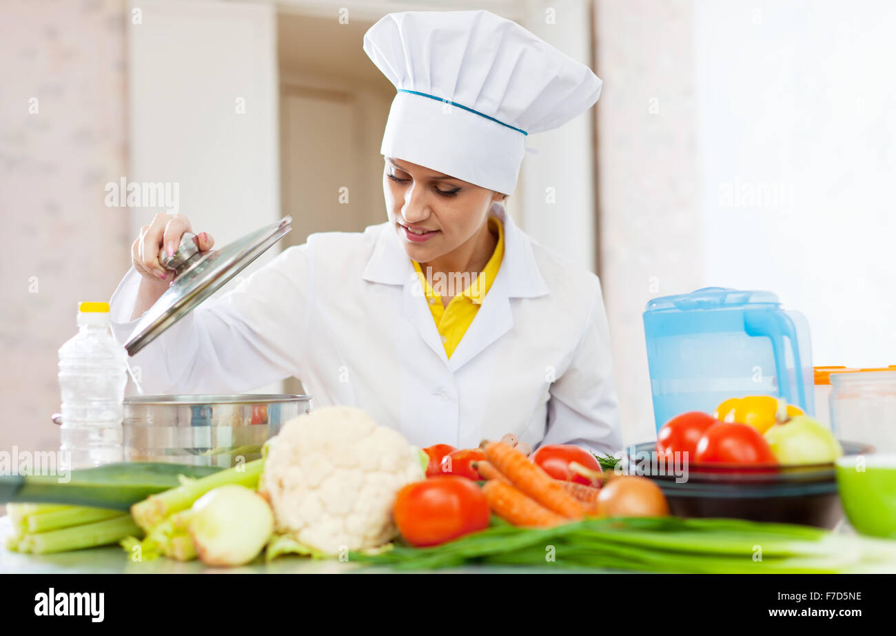 Cook looks into the pan in kitchen Stock Photo - Alamy