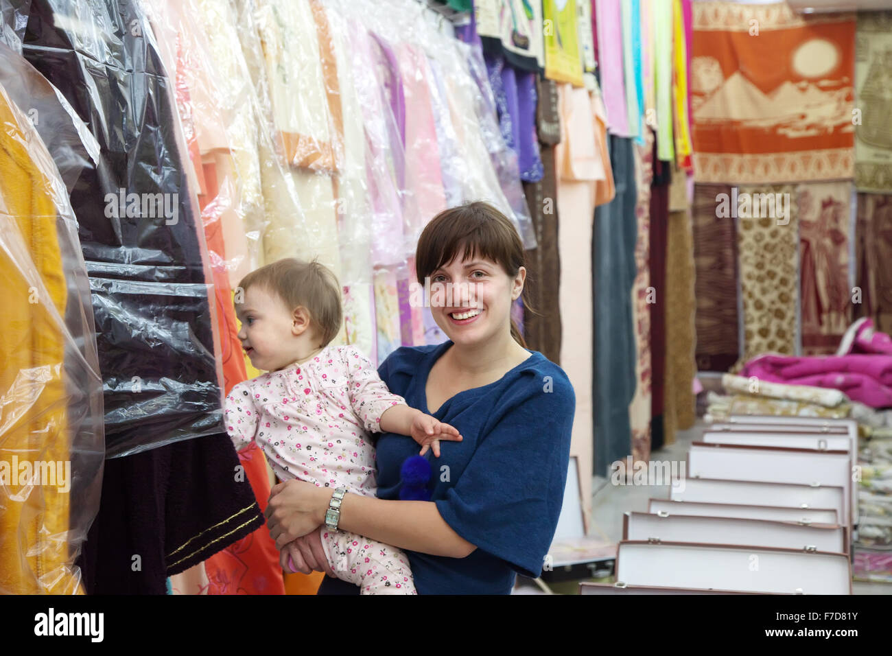 Happy mother and daughter chooses clothes at shop Stock Photo - Alamy