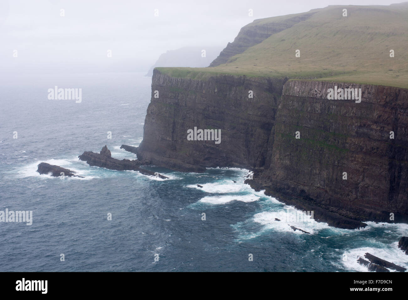 Typical landscape on the Faroe Islands, with green grass, cliff and ...