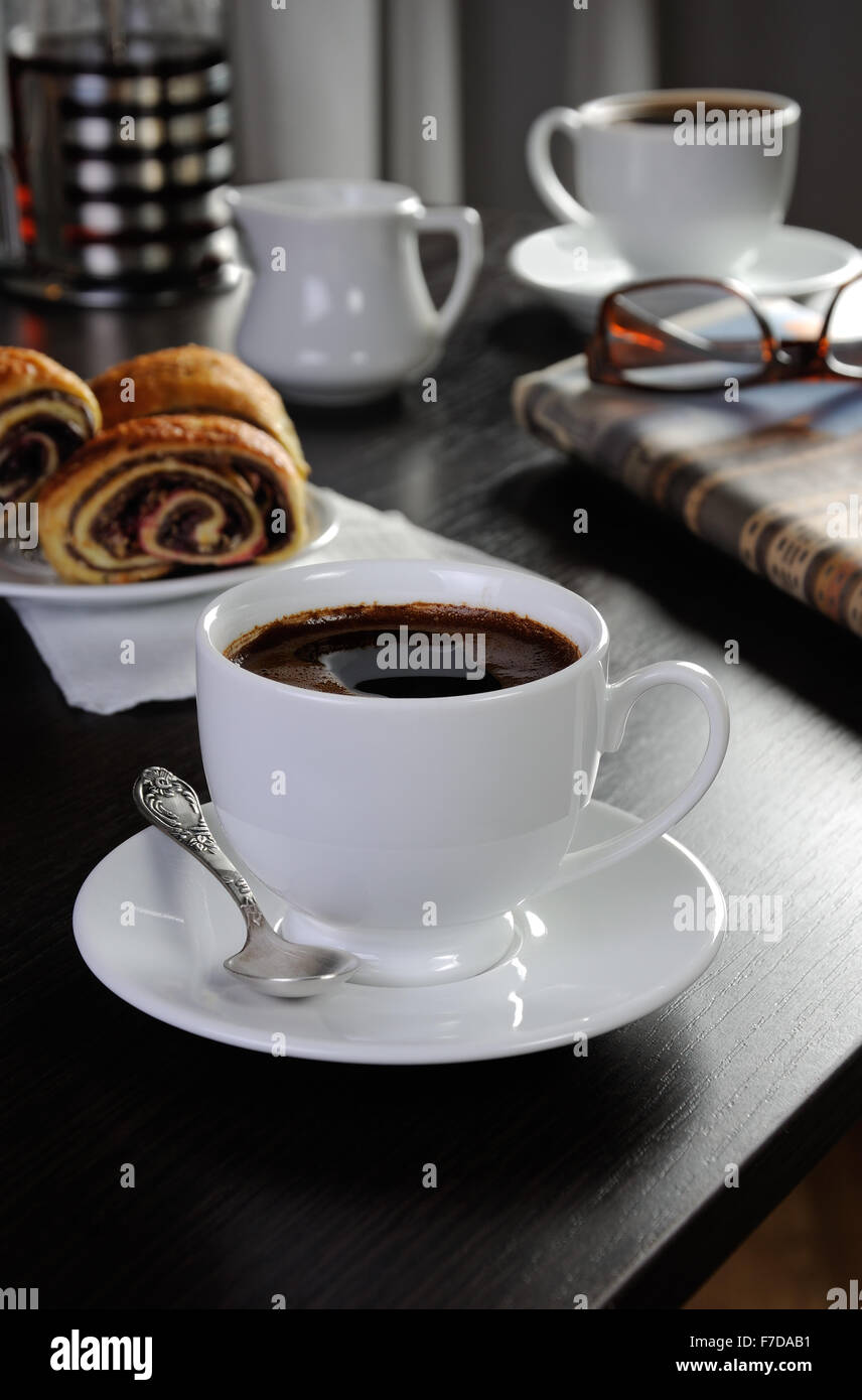 cup of coffee on the table with bread rolls and newspapers Stock Photo ...