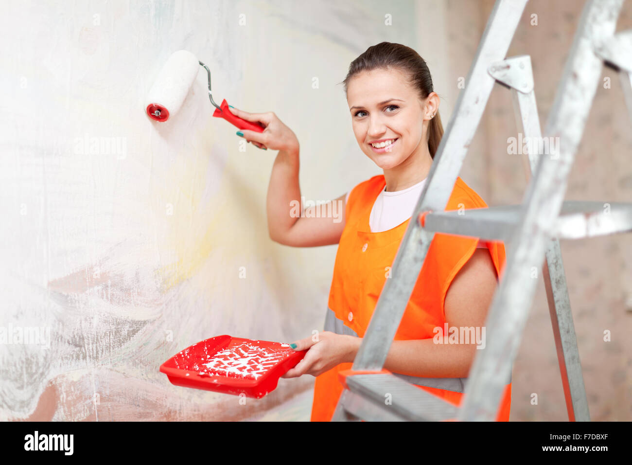Female house painter paints wall with roller Stock Photo - Alamy
