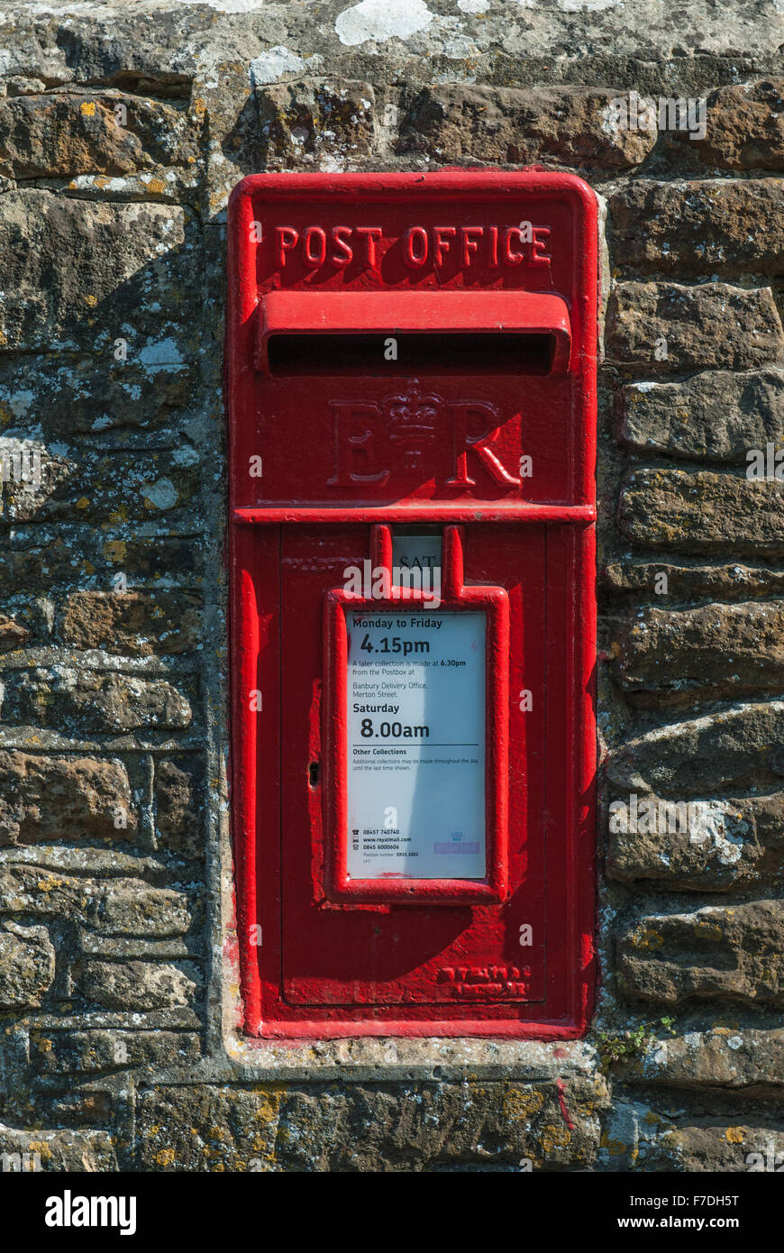 Red post box mounted in stone wall, England Stock Photo - Alamy