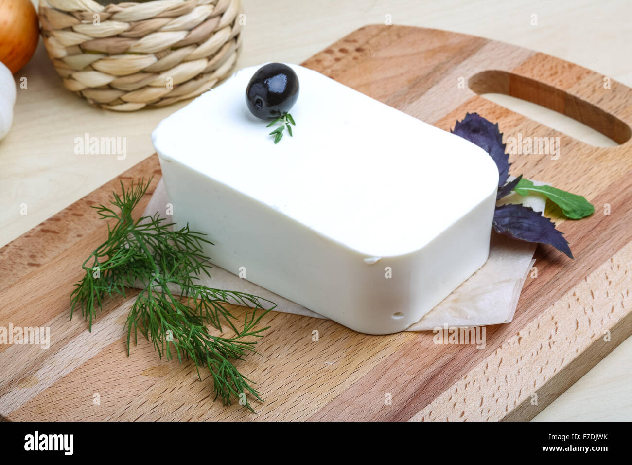 Feta cheese slice on the board with herbs Stock Photo - Alamy