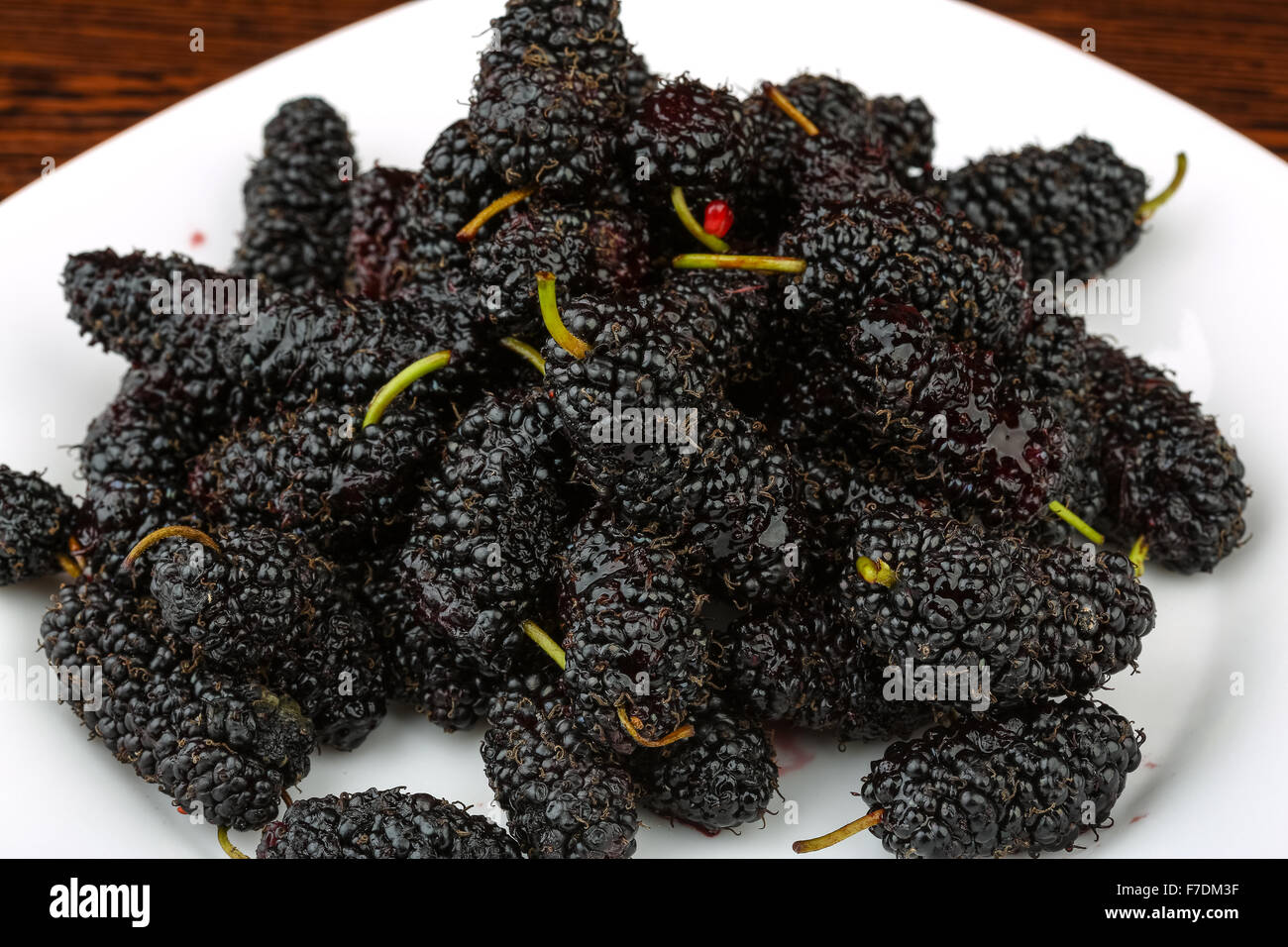 Fresh ripes Mulberry on the plate wood background Stock Photo - Alamy