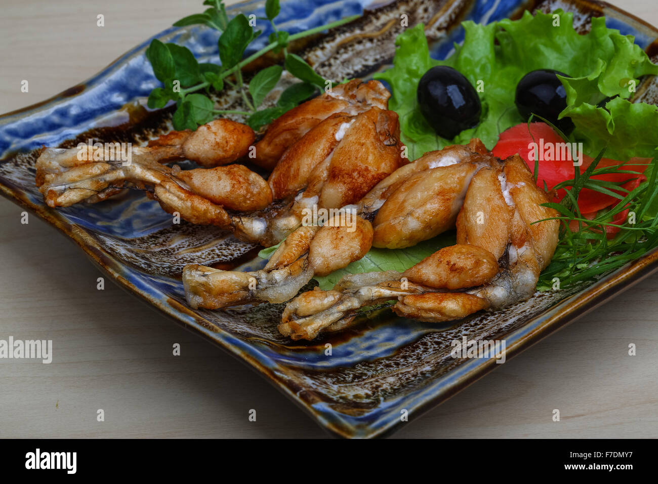 Roasted Frog legs with herbs and spices Stock Photo - Alamy