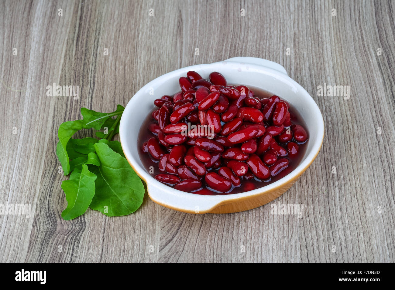 Red kidney on the bowl with ruccola leaves wood background Stock Photo ...