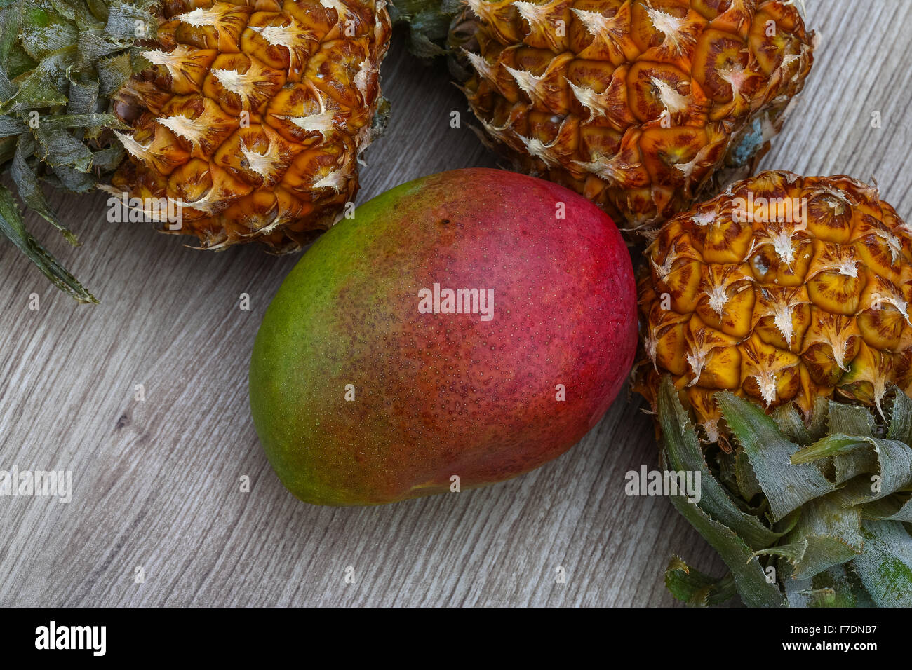 Mini pineapple and mango fruit on the wood background Stock Photo - Alamy