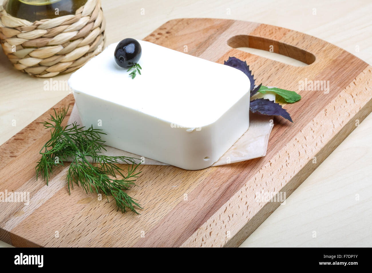 Feta cheese slice on the board with herbs Stock Photo - Alamy
