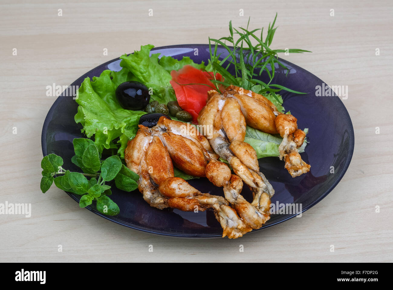 Roasted Frog legs with herbs and spices Stock Photo - Alamy