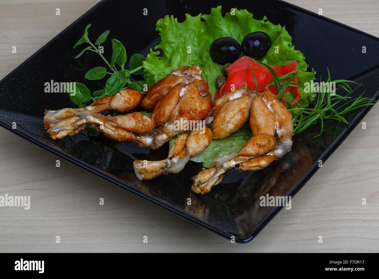 Roasted Frog legs with herbs and spices Stock Photo - Alamy