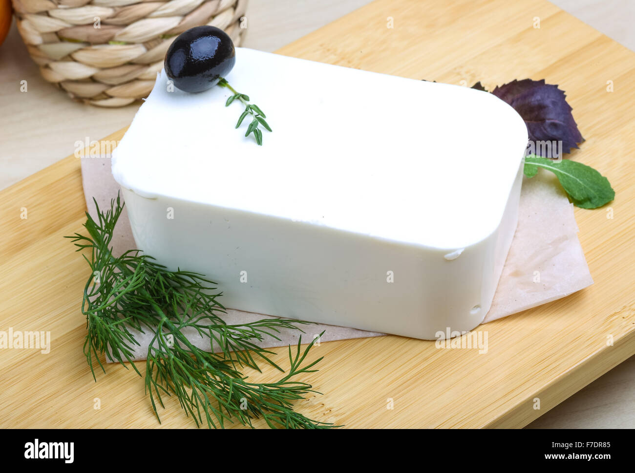 Feta cheese slice on the board with herbs Stock Photo - Alamy