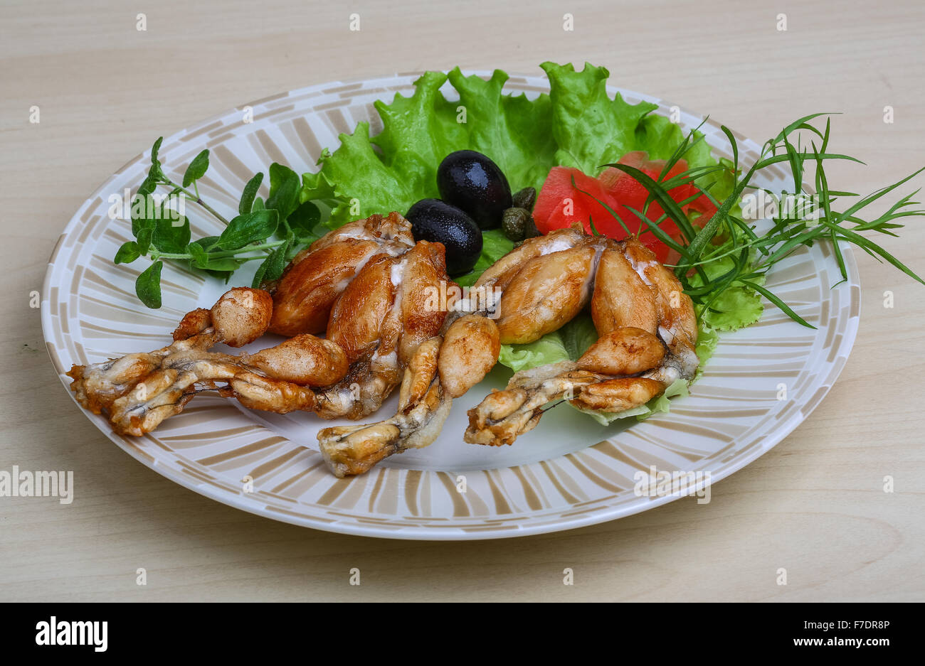 Roasted Frog legs with herbs and spices Stock Photo - Alamy