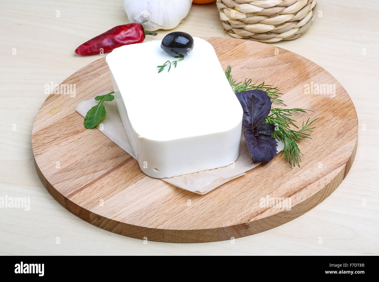 Feta cheese slice on the board with herbs Stock Photo - Alamy