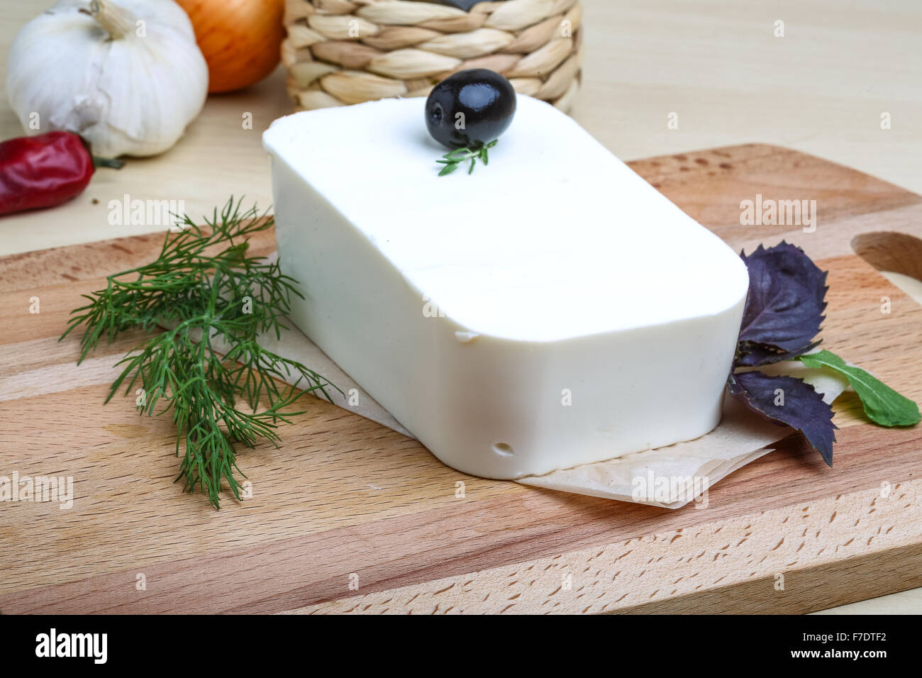 Feta cheese slice on the board with herbs Stock Photo - Alamy