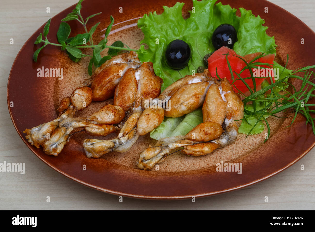 Roasted Frog legs with herbs and spices Stock Photo - Alamy