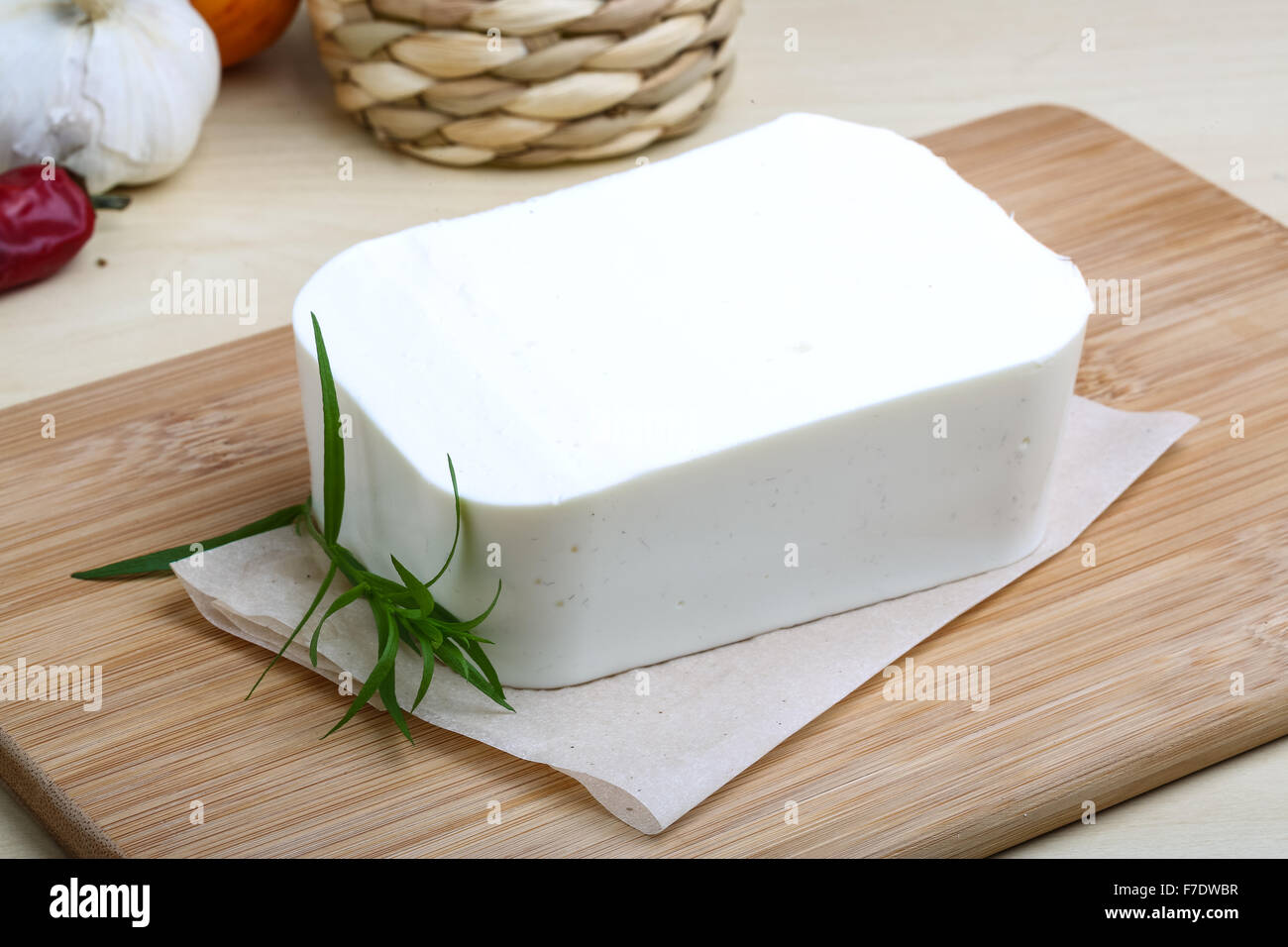 Feta cheese slice on the board with herbs Stock Photo - Alamy