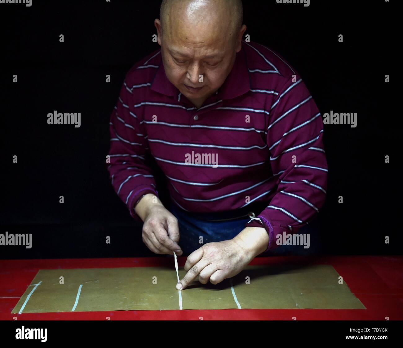 Beijing, China. 29th Nov, 2015. Artist Wang Yuwei fixes an ancient ...