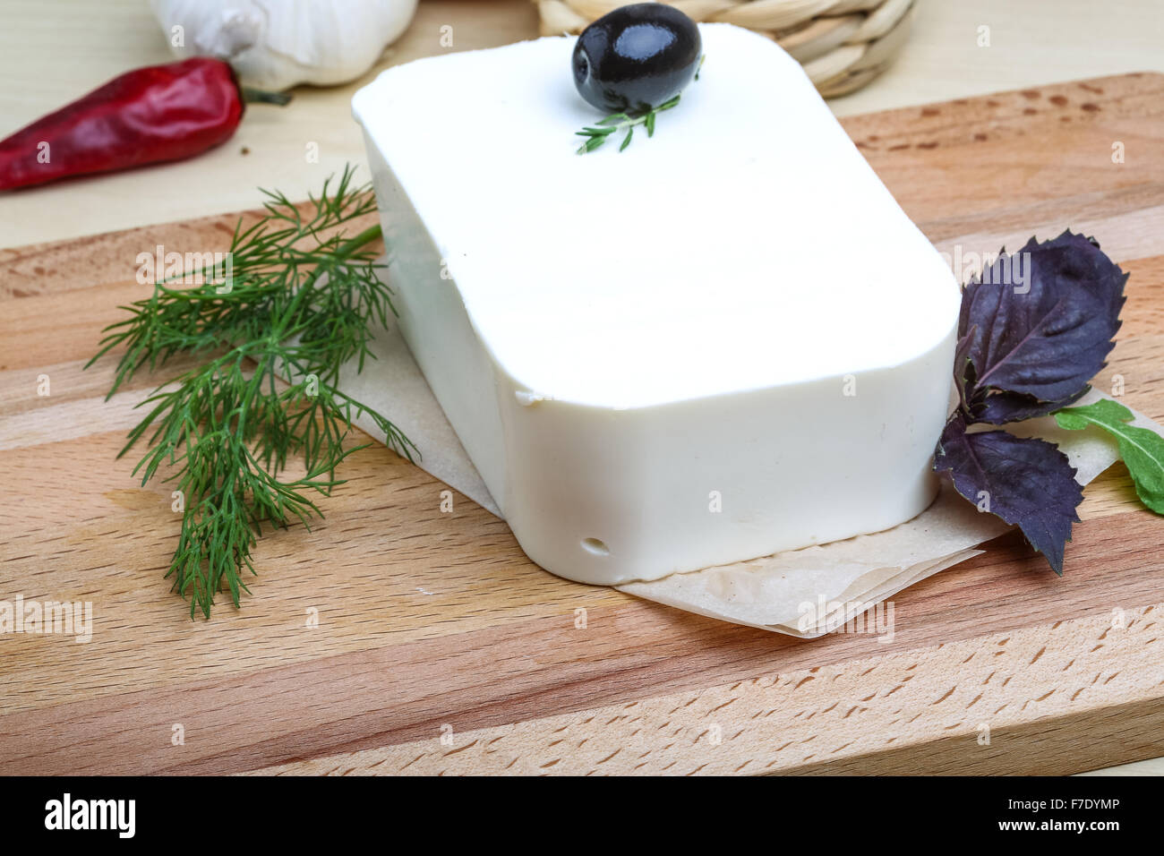 Feta cheese slice on the board with herbs Stock Photo - Alamy