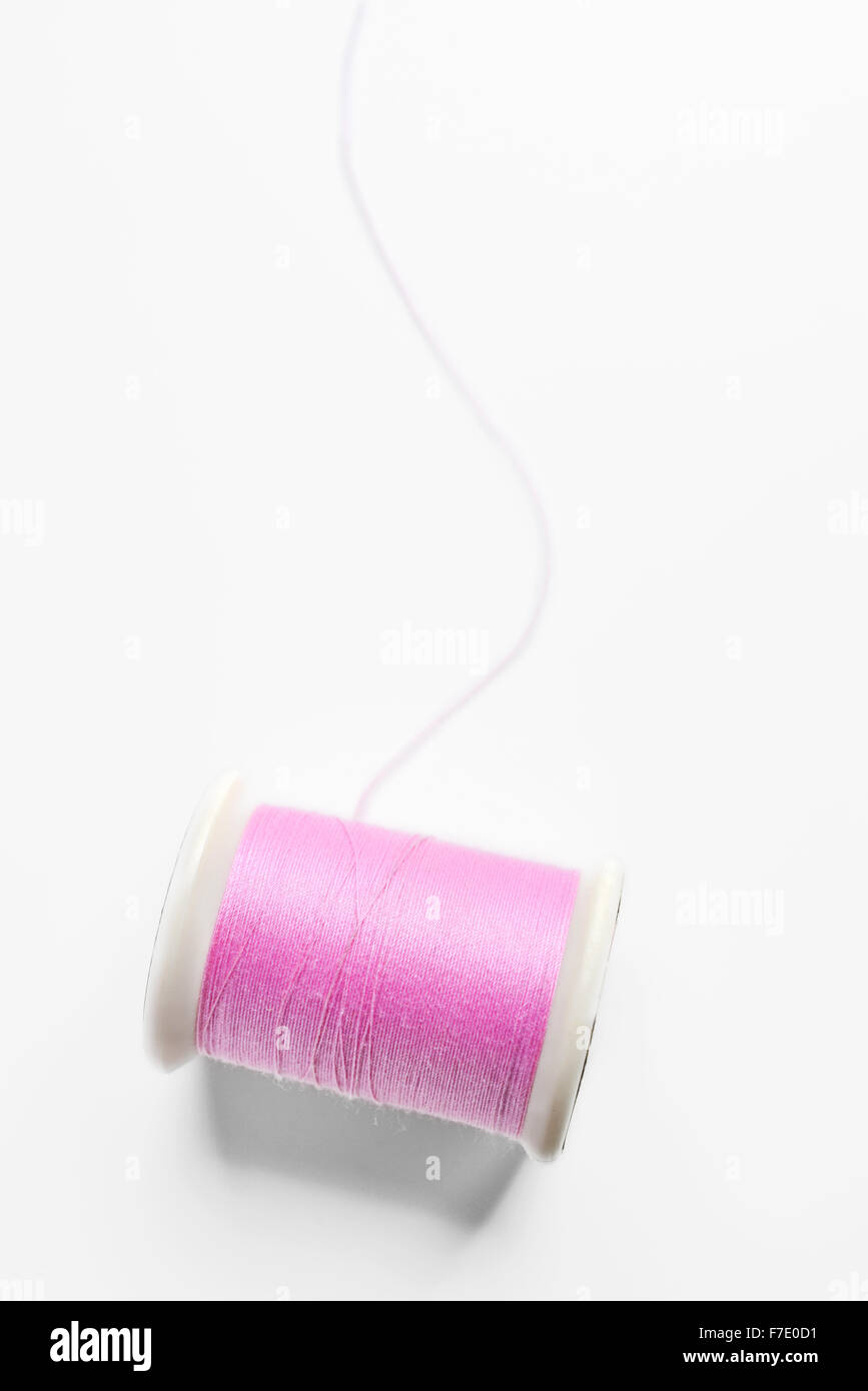 pink thread on white background Stock Photo - Alamy
