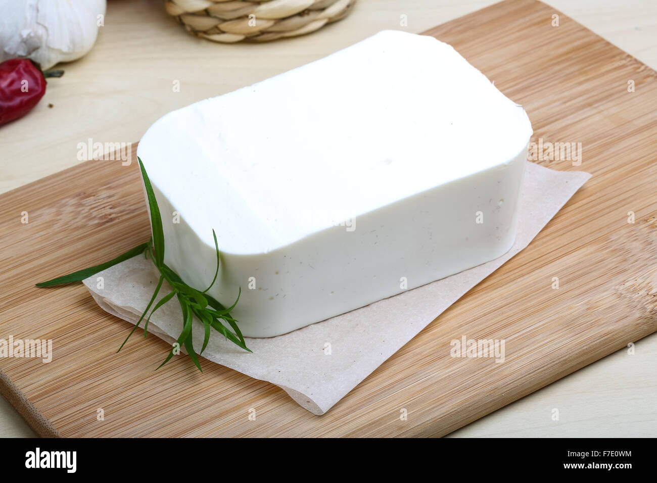Feta cheese slice on the board with herbs Stock Photo - Alamy