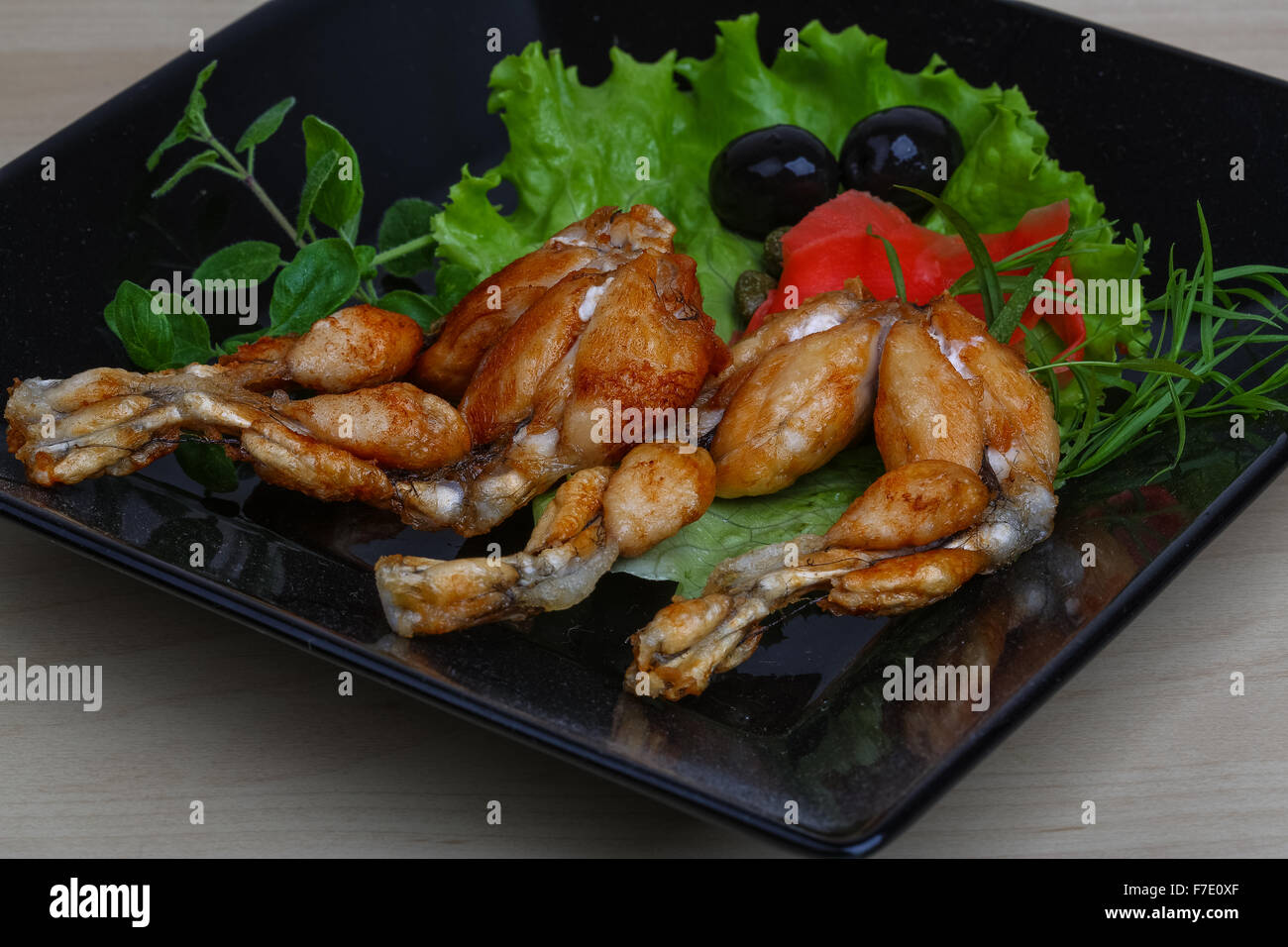 Roasted Frog legs with herbs and spices Stock Photo - Alamy