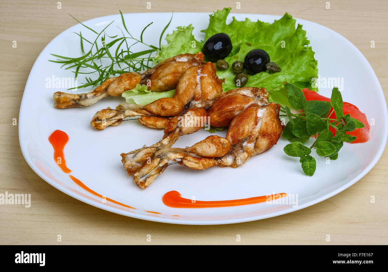 Fried frog legs with herbs on the wood background Stock Photo - Alamy