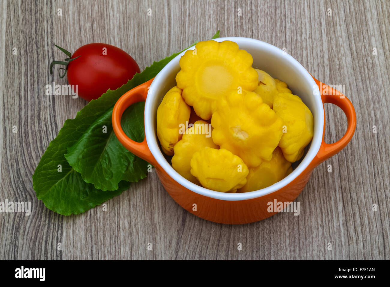 Pickled yellow patissons with salad leaves and fresh tomato Stock Photo ...