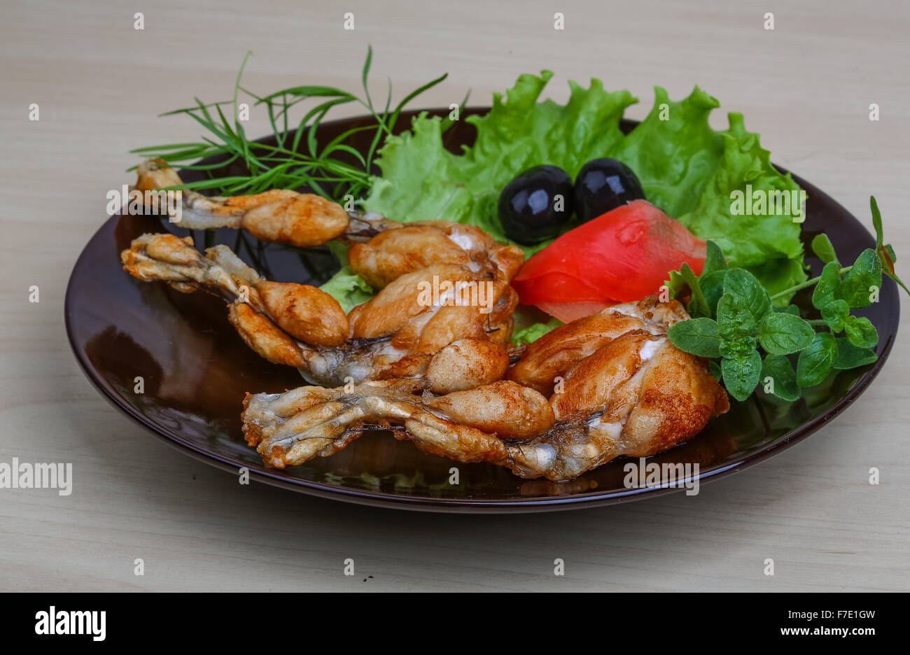 Fried frog legs with olive, herbs and spices Stock Photo - Alamy
