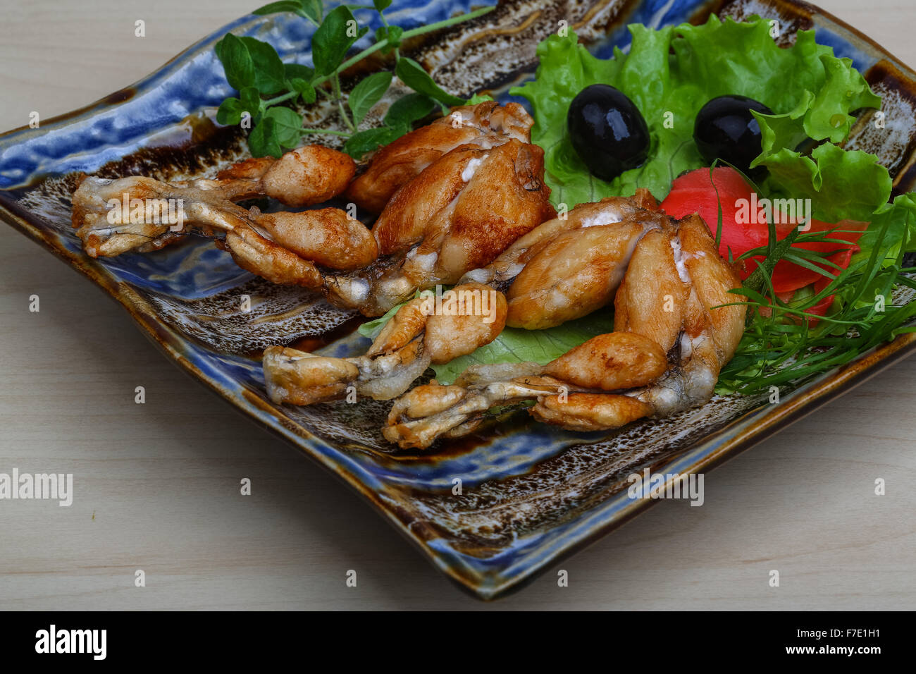 Roasted Frog legs with herbs and spices Stock Photo - Alamy