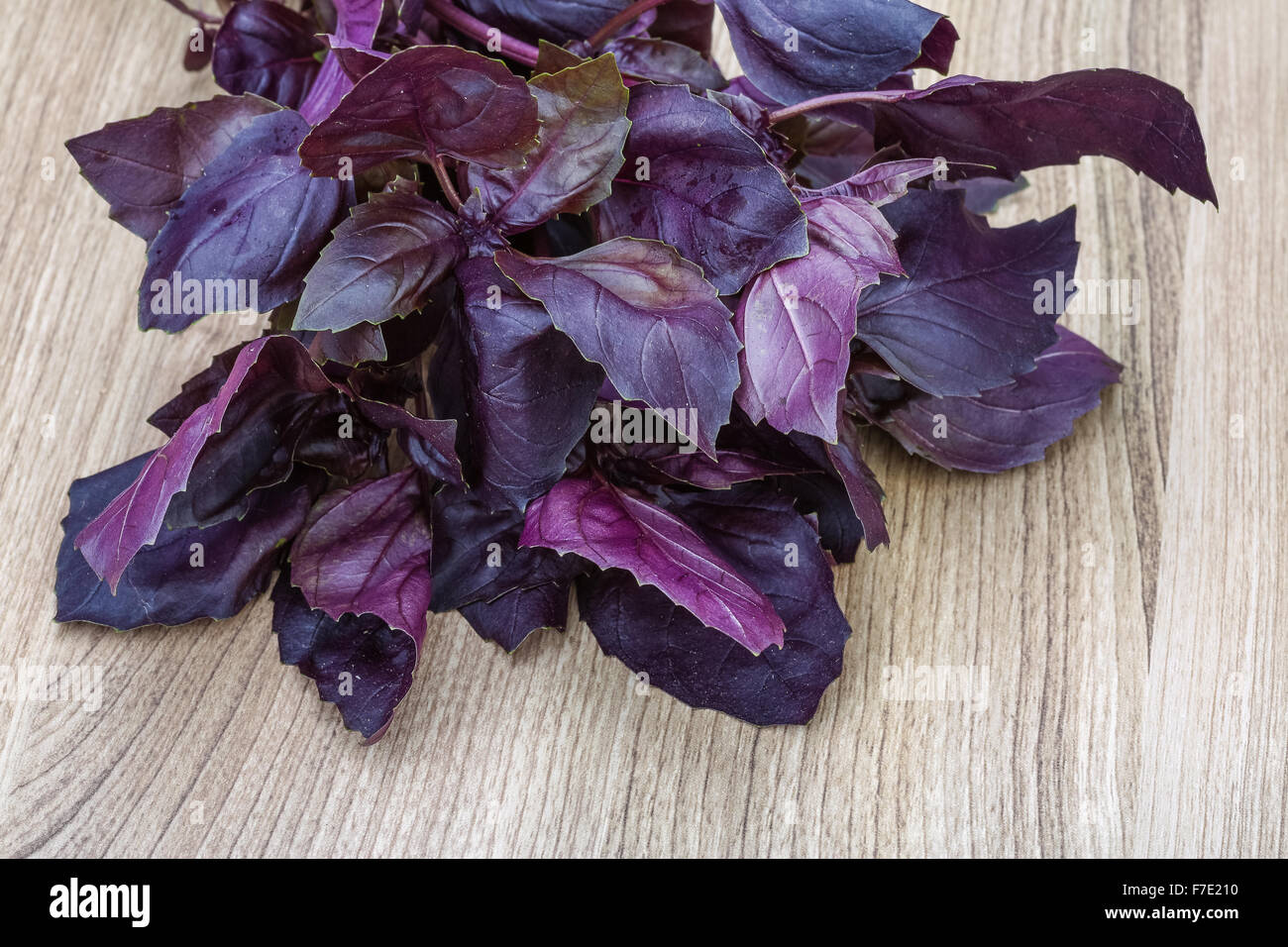 Fresh violet Basil leaves heap on the wood background Stock Photo - Alamy