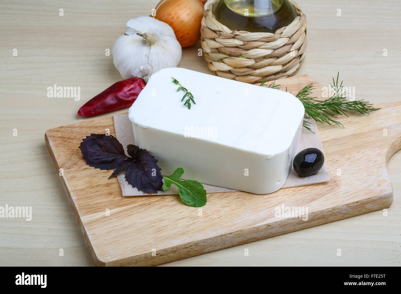 Feta cheese slice on the board with herbs Stock Photo - Alamy