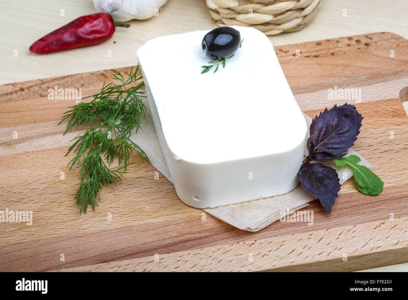 Feta cheese slice on the board with herbs Stock Photo - Alamy