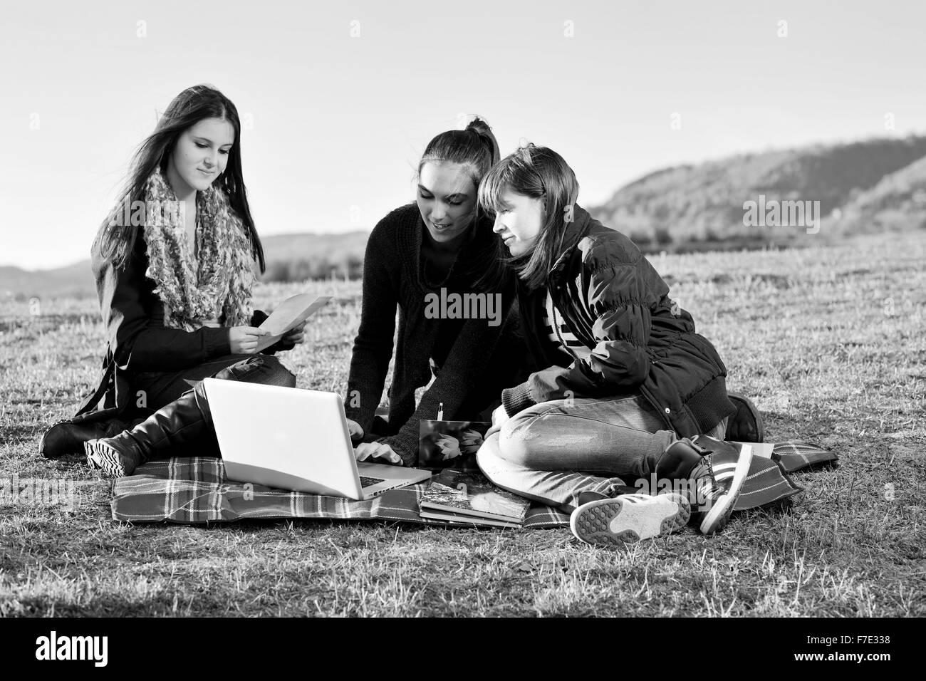 group of teen girl woman outdoor have fun and study homework on laptop ...
