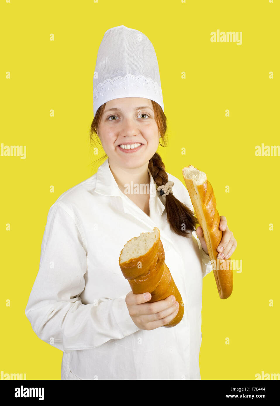 female baker is showing French long baton over yellow Stock Photo - Alamy